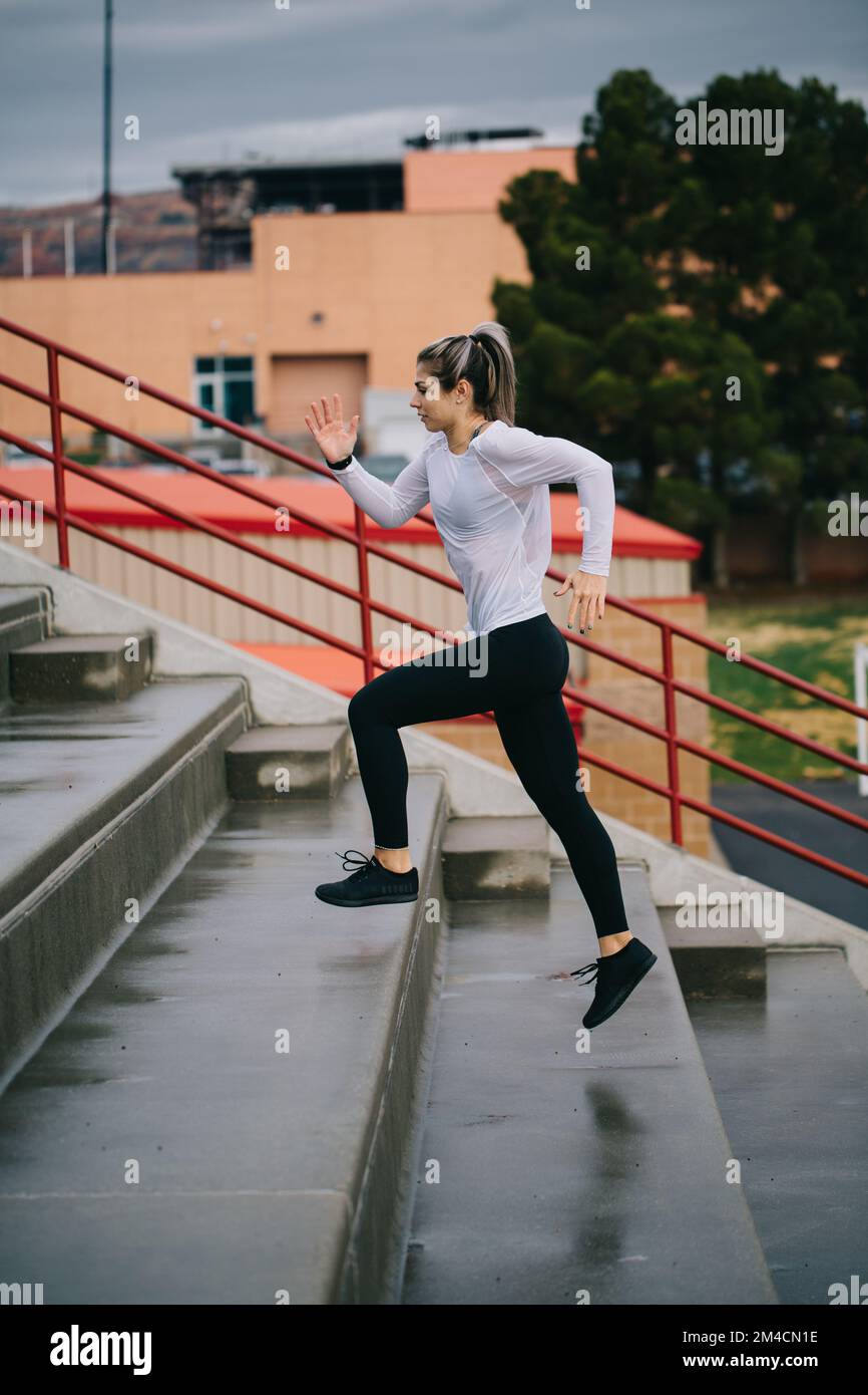 Runner woman running stairs outside on a rainy day at college st Stock ...