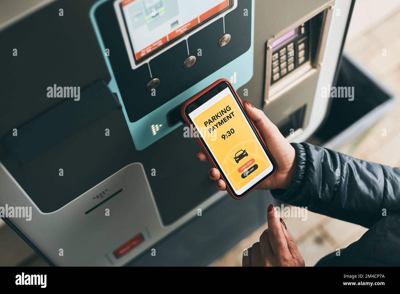 Woman paying for parking ticket at car parking payment machine using ...