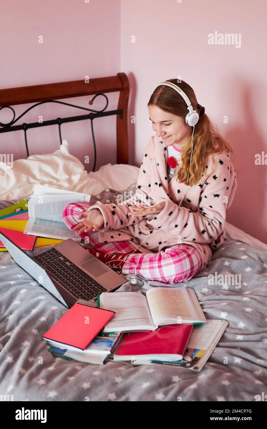 Student learning online, watching lesson remotely, listening to ...