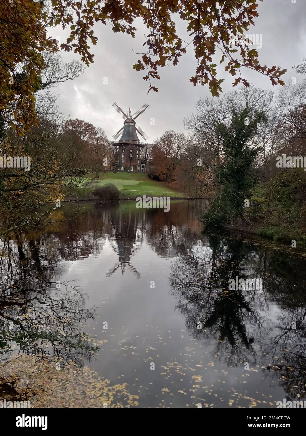 A river surrounded by autumn-colored trees with a background of a ...