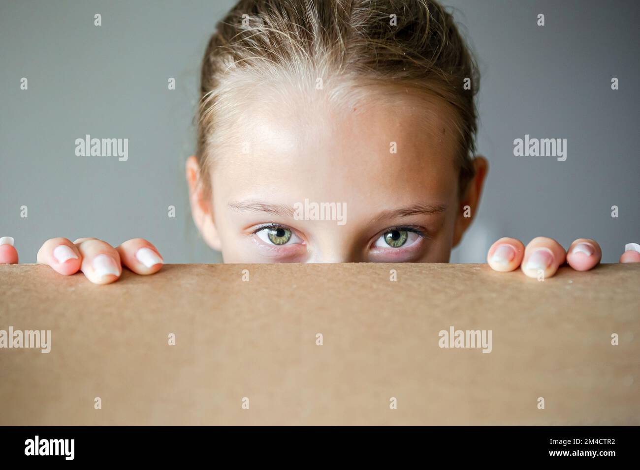 Happy girl with beautiful green eyes in new house with cardboard box ...