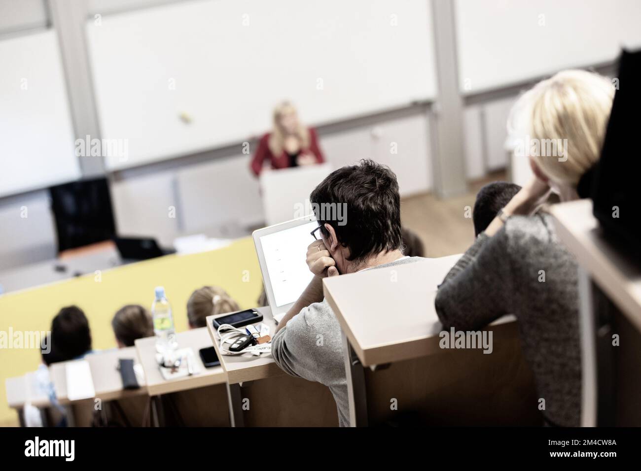 Speaker giving presentation in lecture hall at university. Participants ...