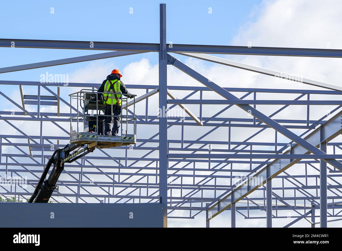 Worker in self propelled articulating boom lift basket in uniform and ...