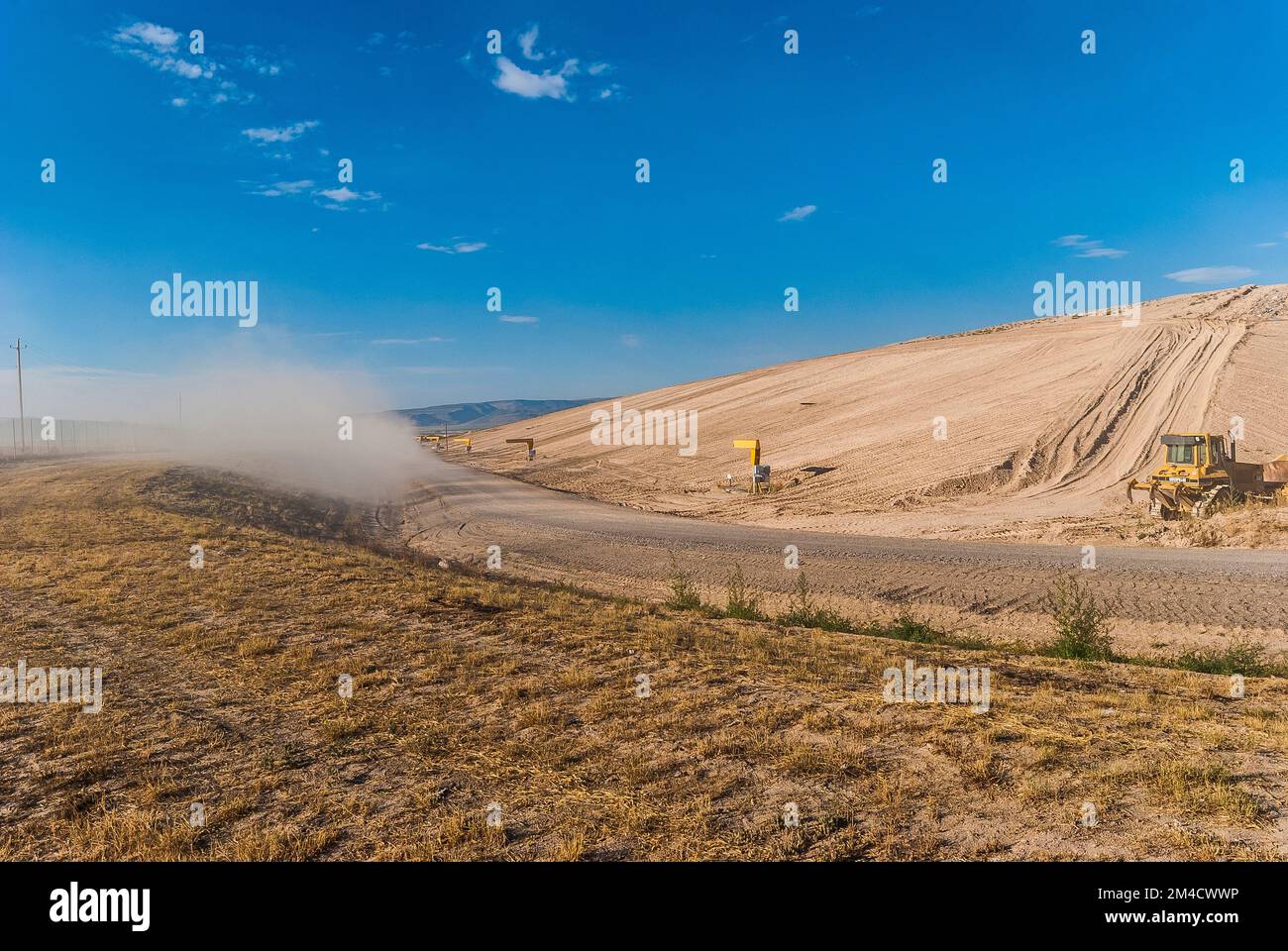 A dust cloud is in the distance, past inverted L-shaped jib crane ...