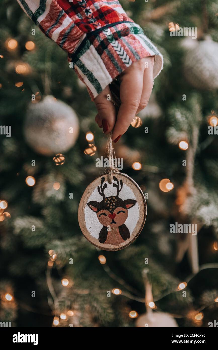 Close-up photo of woman wearing plaid pyjamas, holding diy christmas ...