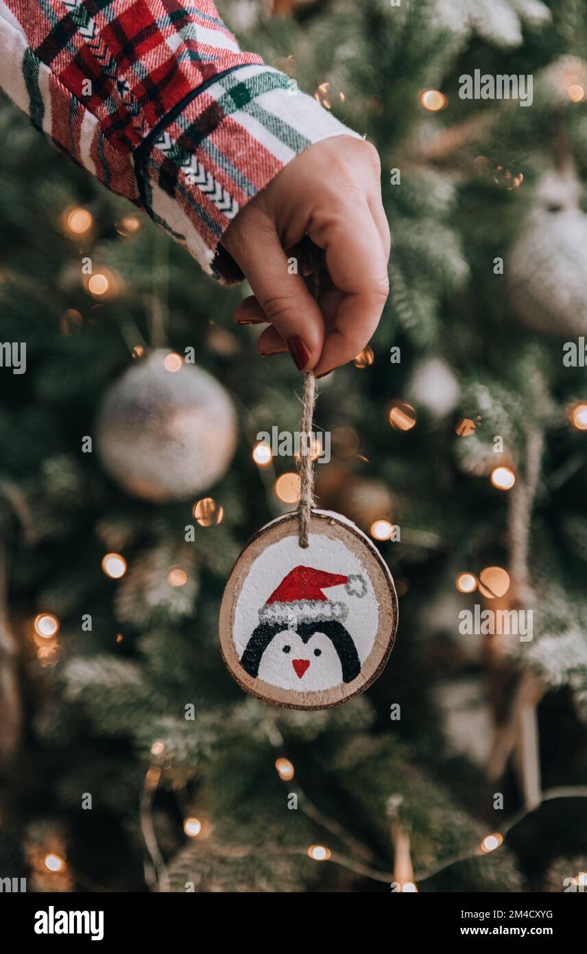 Close-up photo of woman wearing plaid pyjamas, holding diy christmas ...