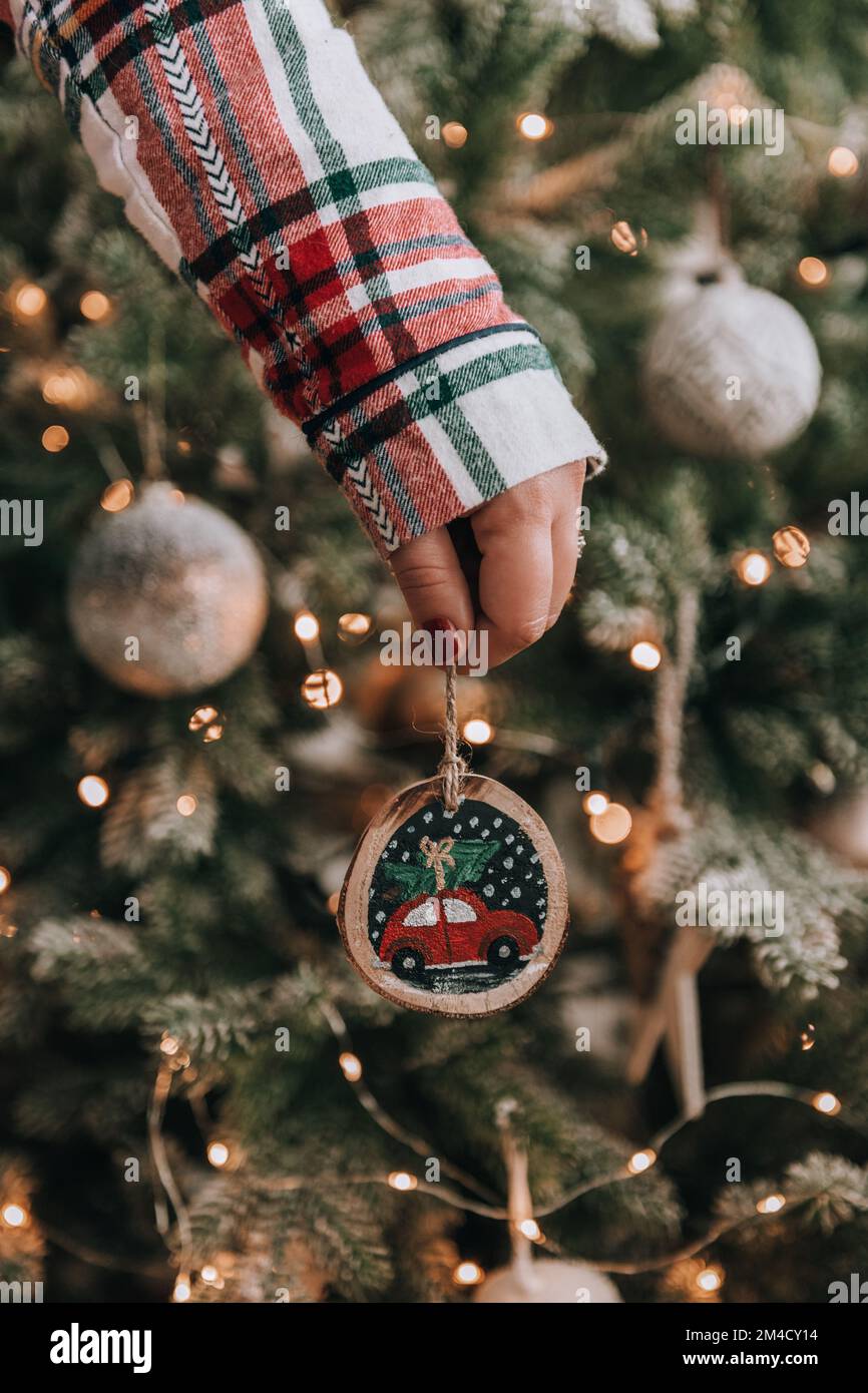 Close-up photo of woman wearing plaid pyjamas, holding diy christmas ...