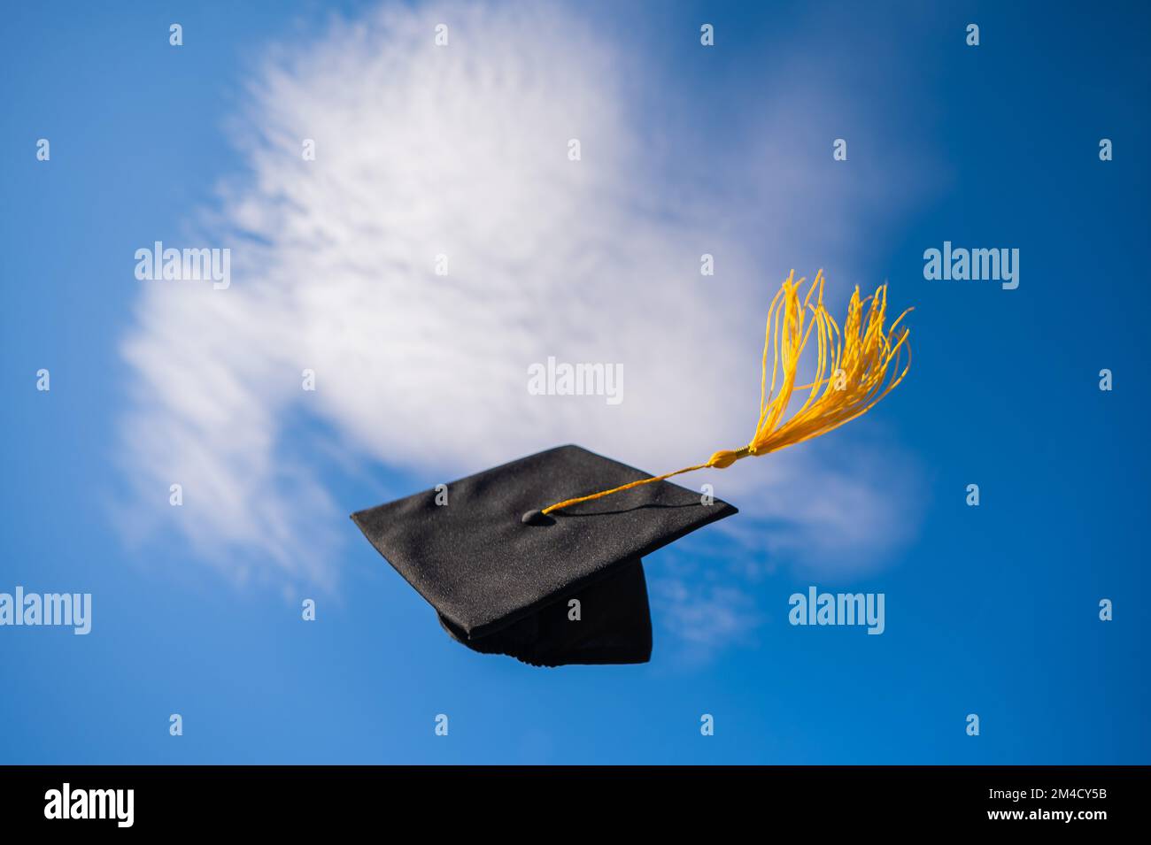 Graduation cap flies against the blue sky Stock Photo - Alamy