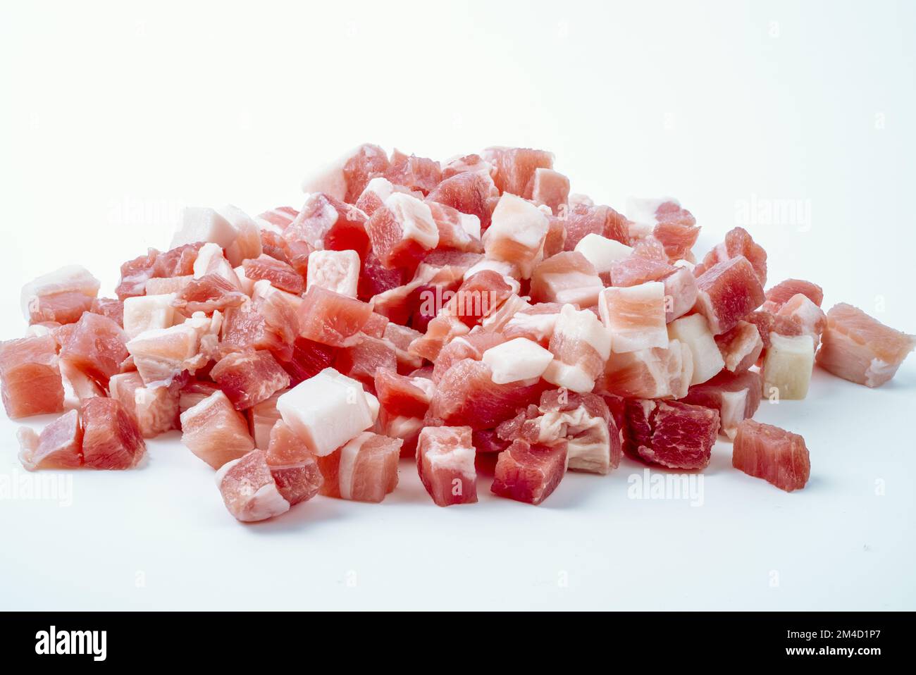 close up of pancetta cured salted pork cubes isolated against a white ...