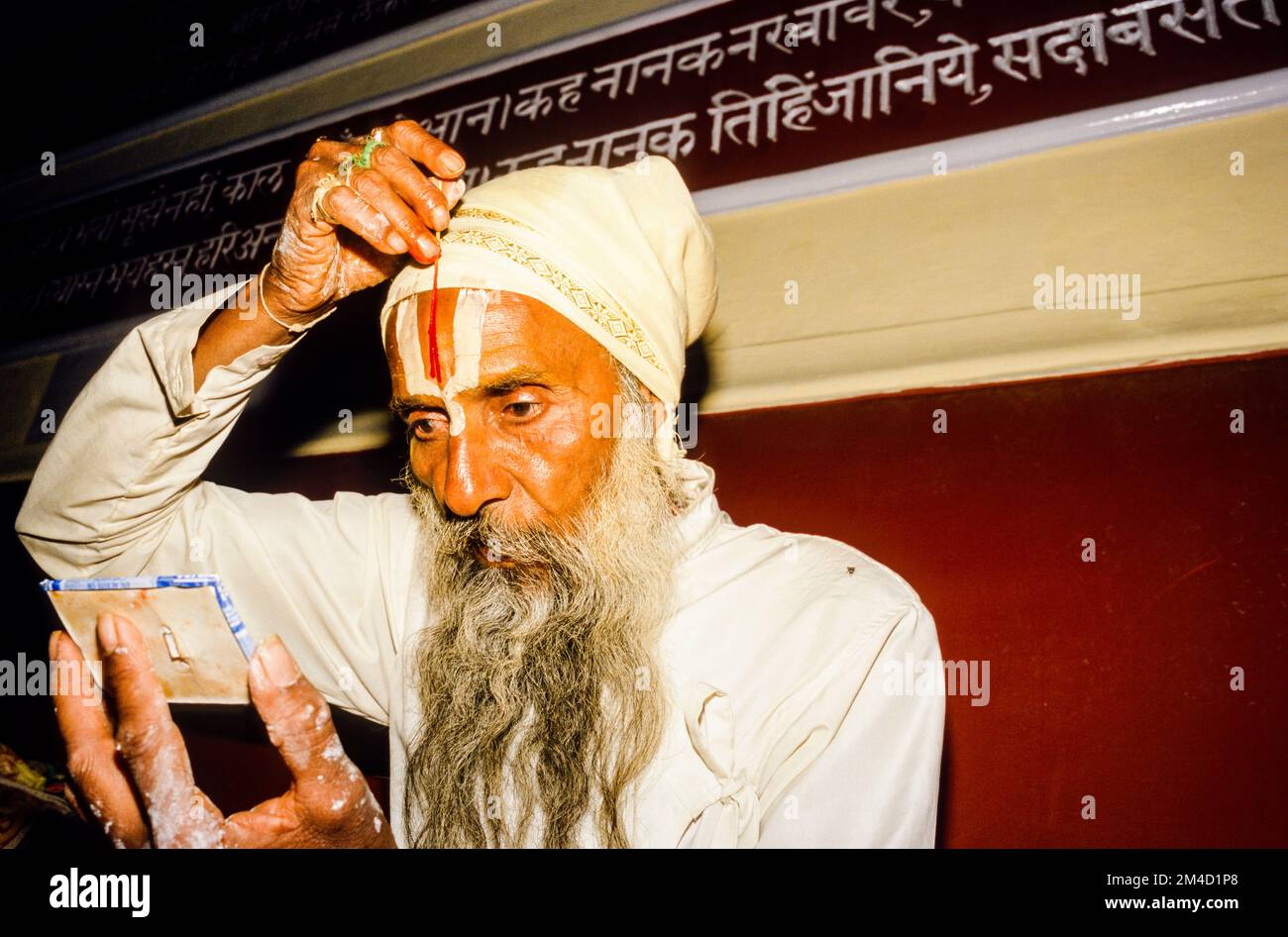 Rama-Sadhu painting a fresh tilak on his forehead on the ghats of ...