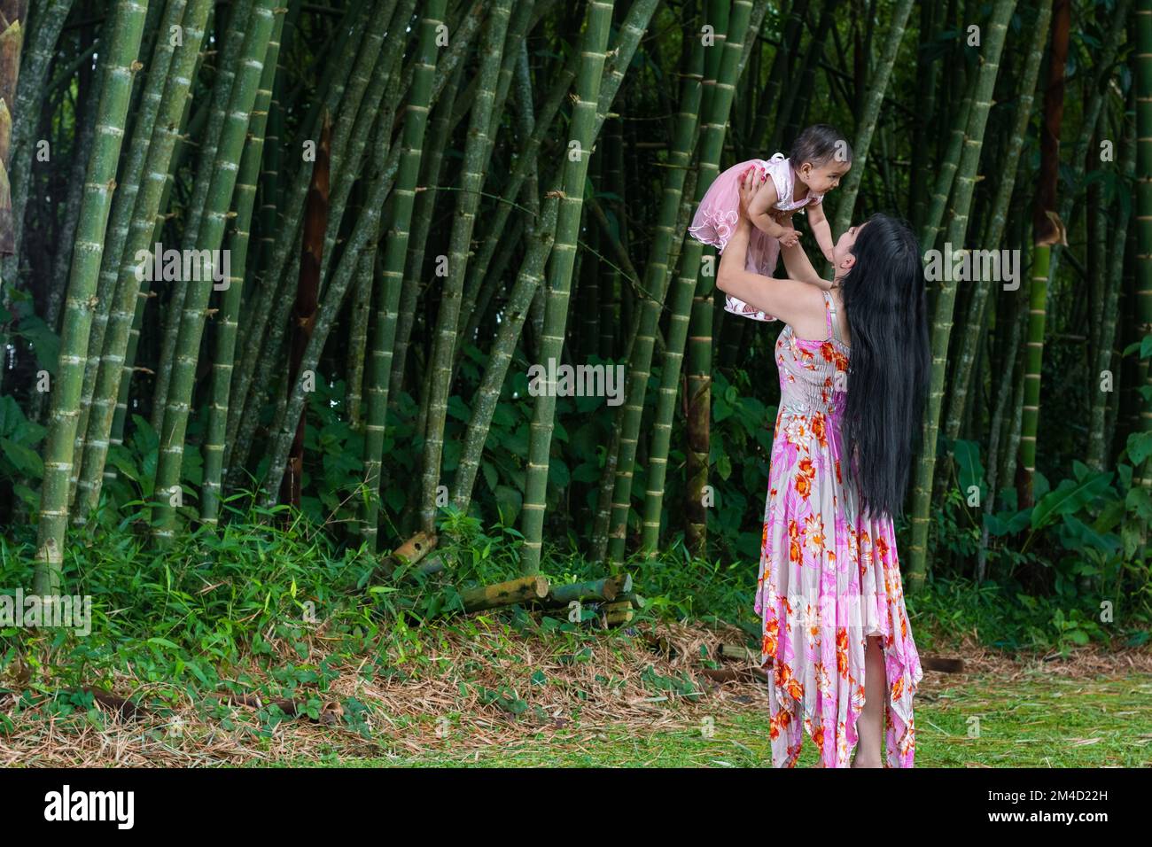latin mother lifting her baby with her arms up, playing with the child ...