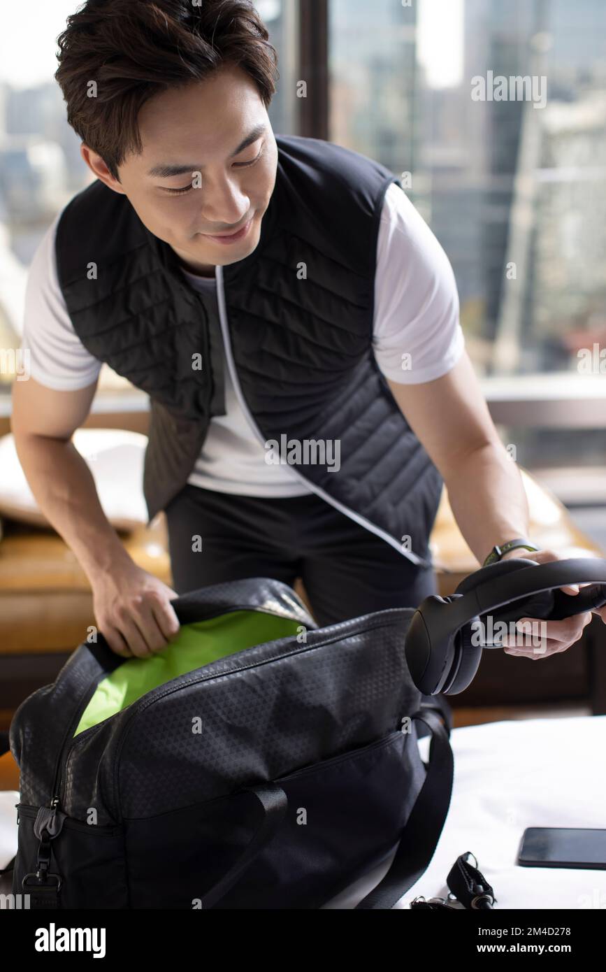 Chinese mid adult man getting ready to go out and workout Stock Photo ...