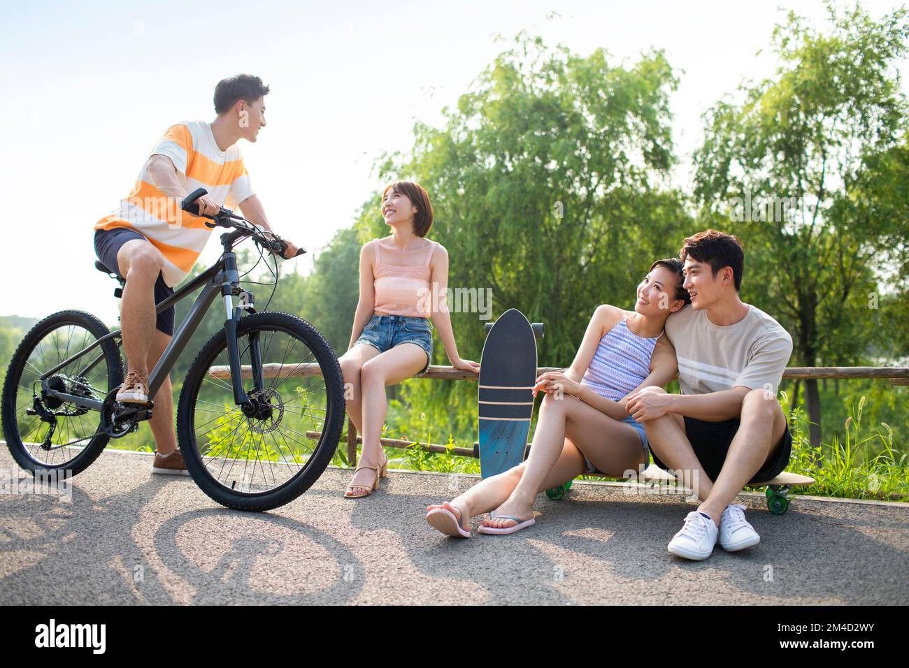 Happy young Chinese friends relaxing in park Stock Photo - Alamy
