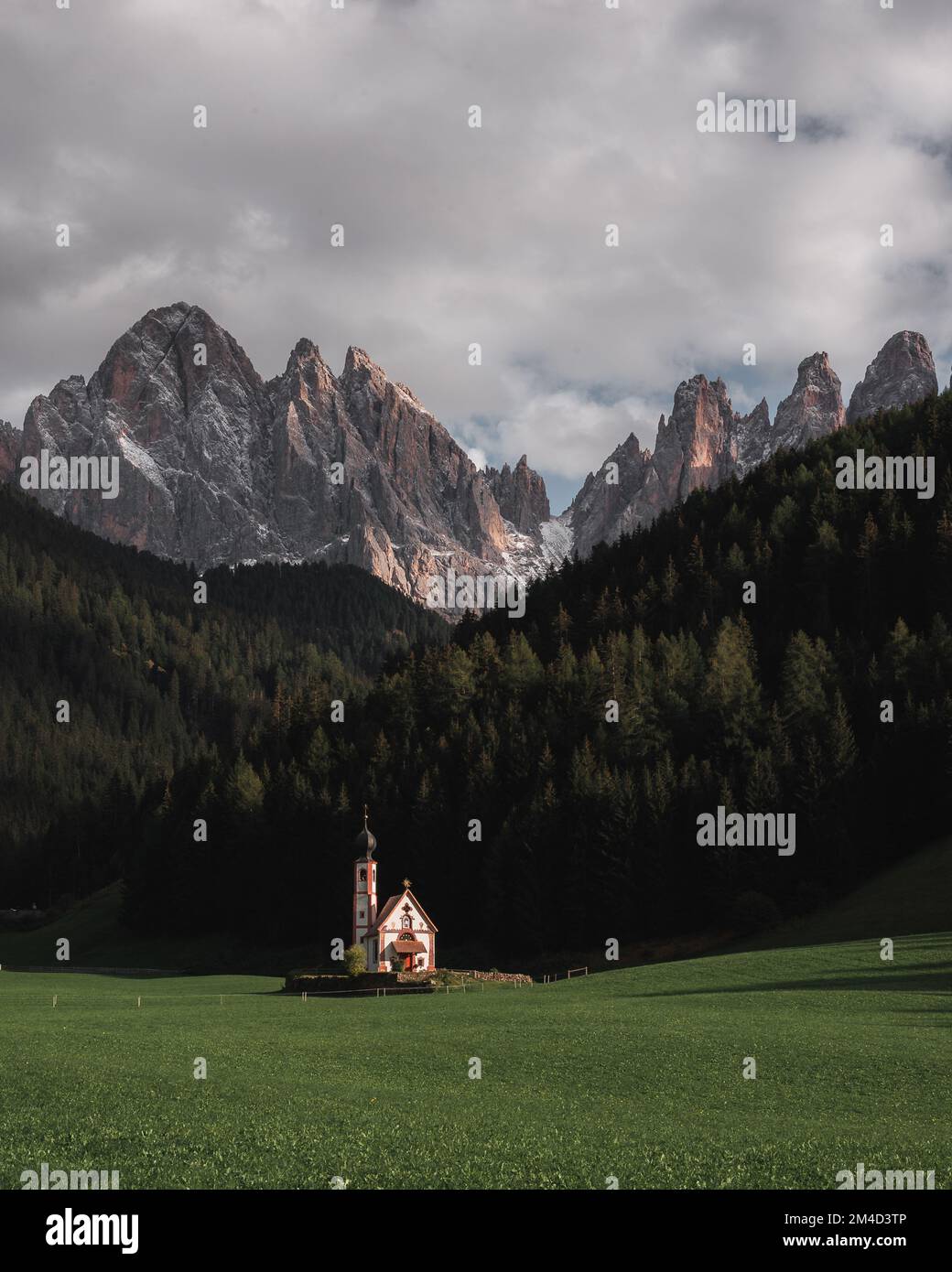 A vertical shot of St. John church in the middle of a scenic landscape ...