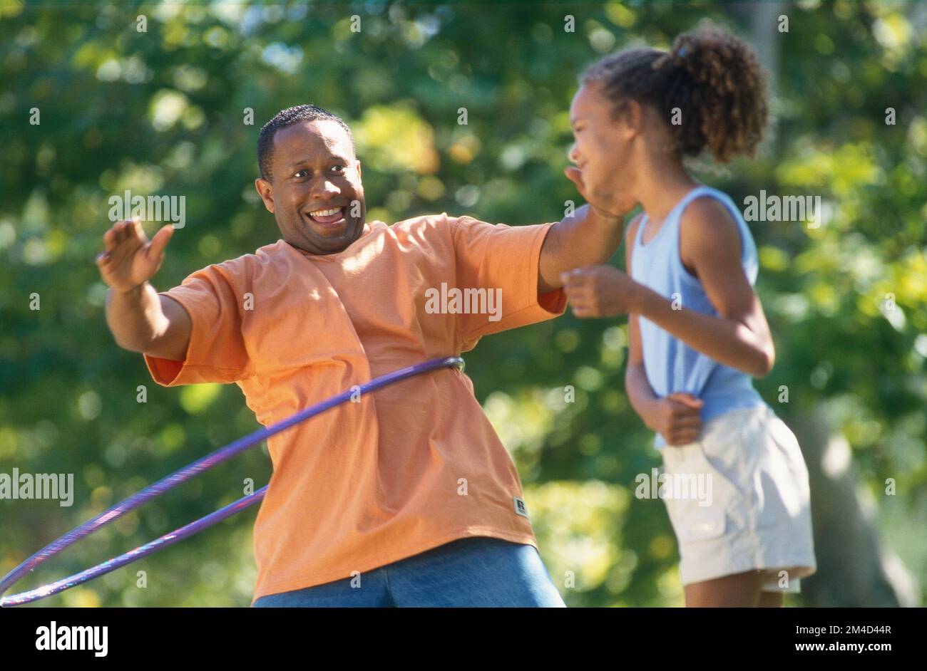 African-American father and daughter outside using a hula hoop Stock ...