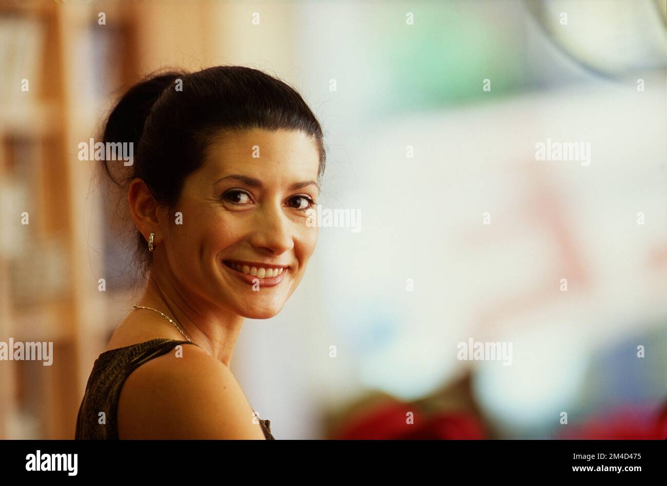 Younger woman looking back smiling at the camera Stock Photo - Alamy