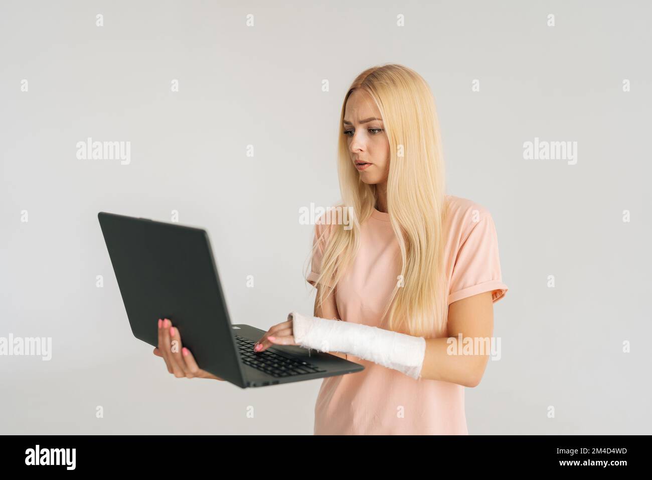 Portrait of scared blonde young woman with broken arm wrapped in ...