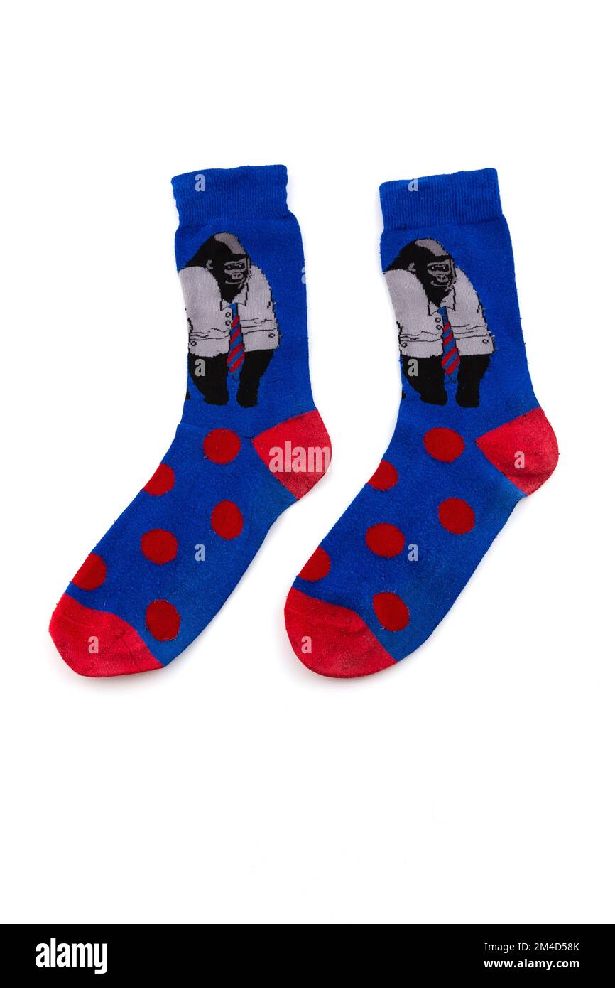 Funy blue socks with monkeys and red dots on them isolated on a white ...