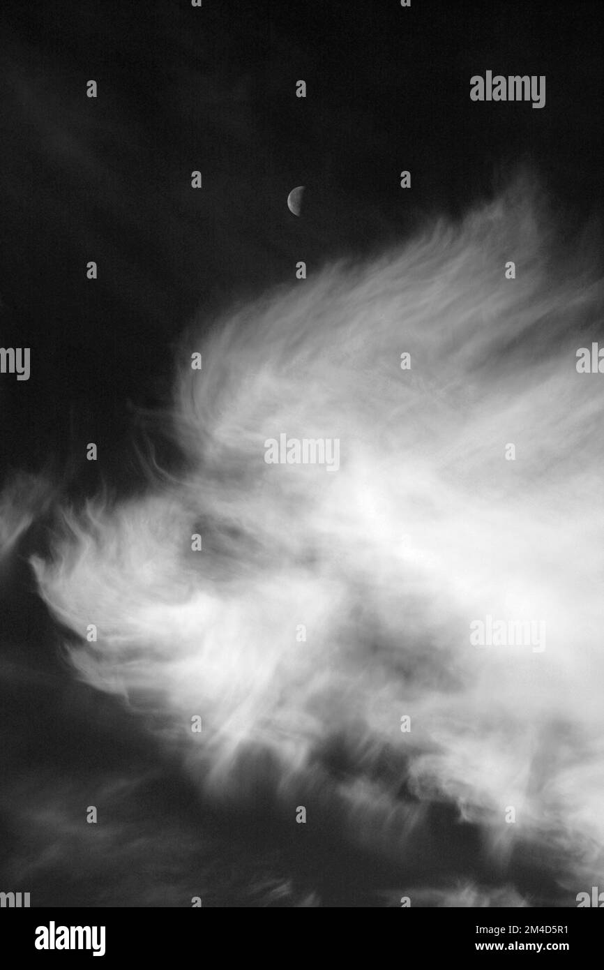 A half moon shares the sky with cirrus clouds over Santa Fe, New Mexico ...