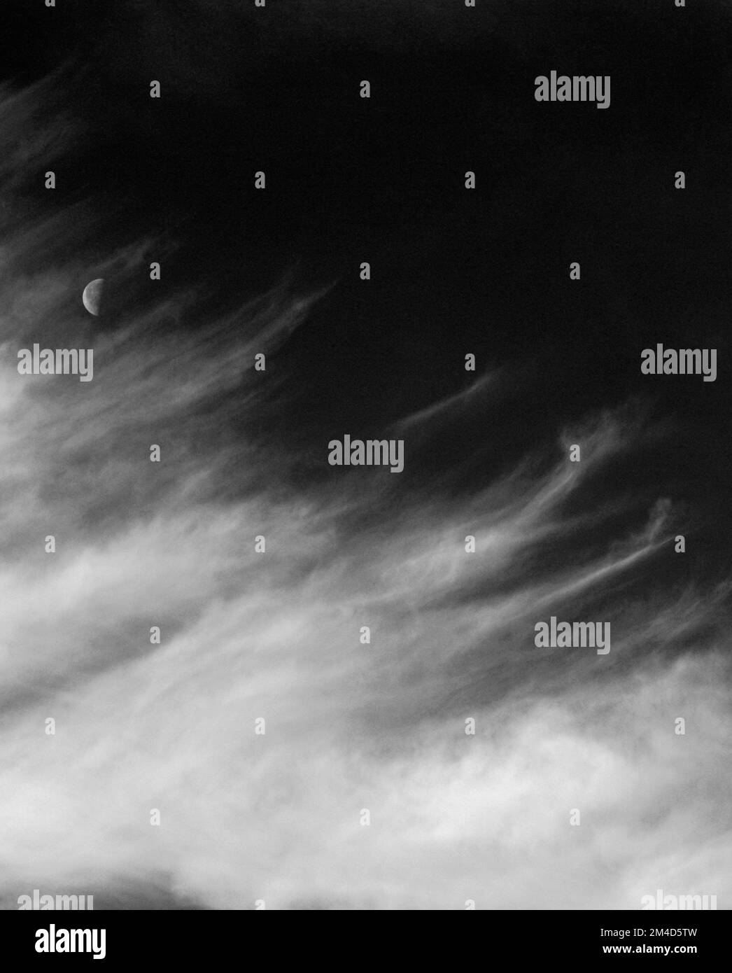 A half moon shares the sky with cirrus clouds over Santa Fe, New Mexico ...