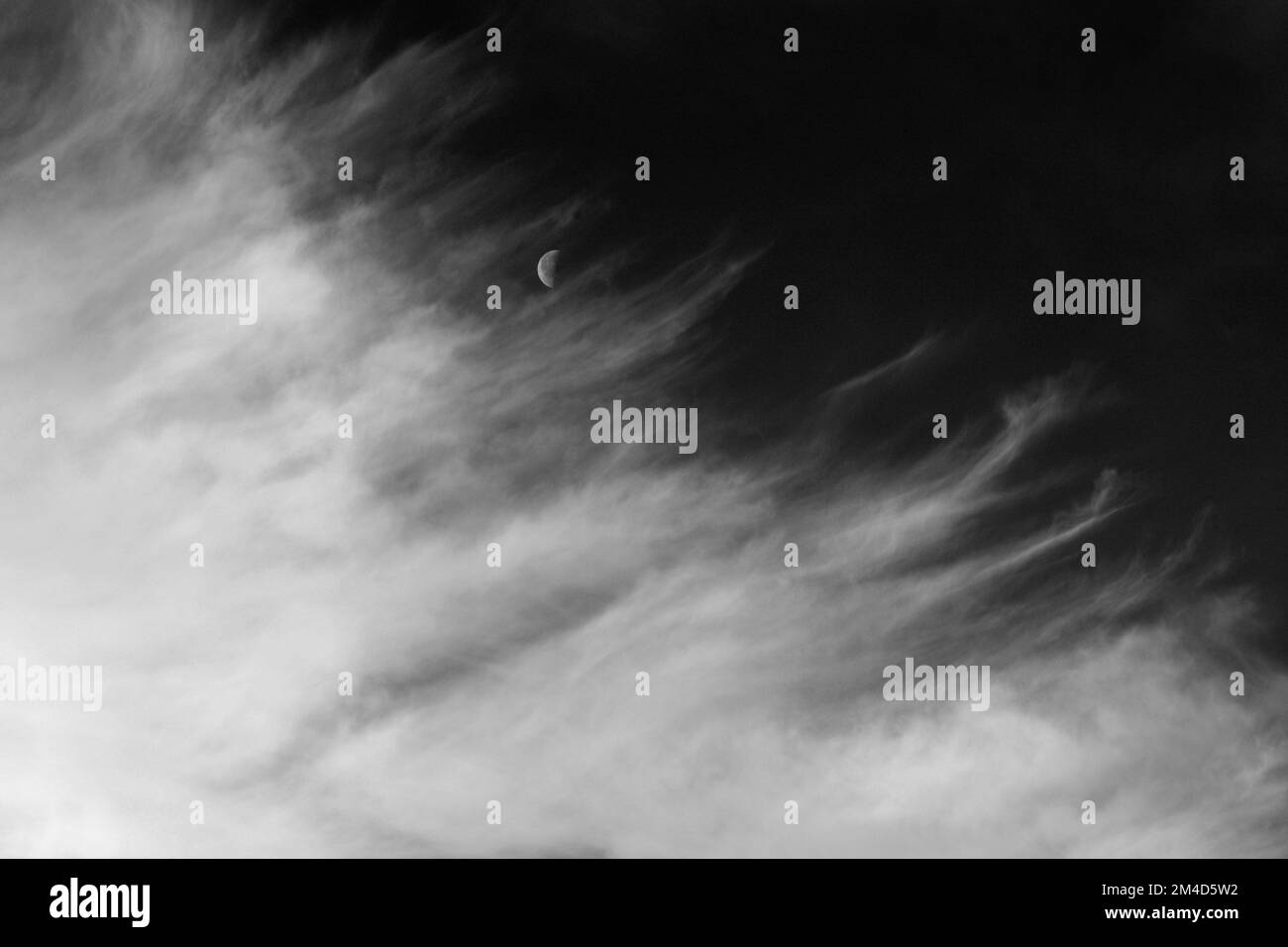A half moon shares the sky with cirrus clouds over Santa Fe, New Mexico ...