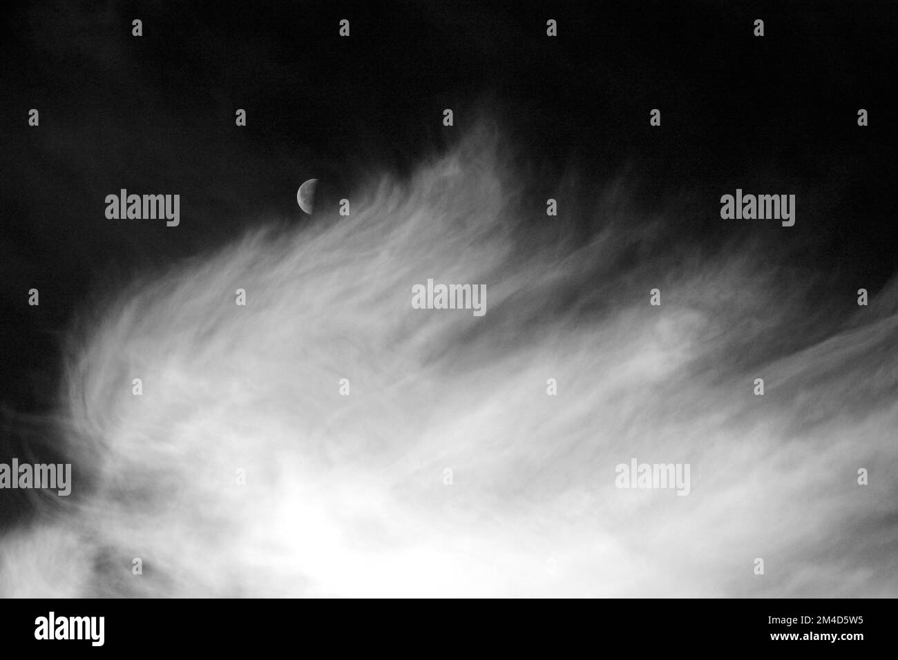 A half moon shares the sky with cirrus clouds over Santa Fe, New Mexico ...