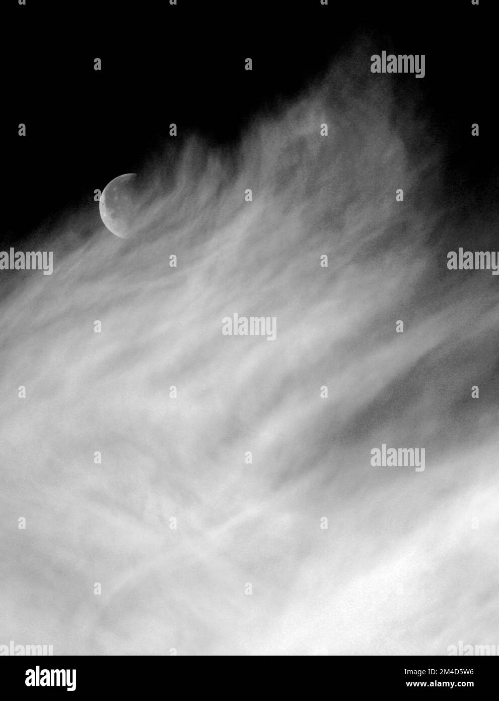 A half moon shares the sky with cirrus clouds over Santa Fe, New Mexico ...