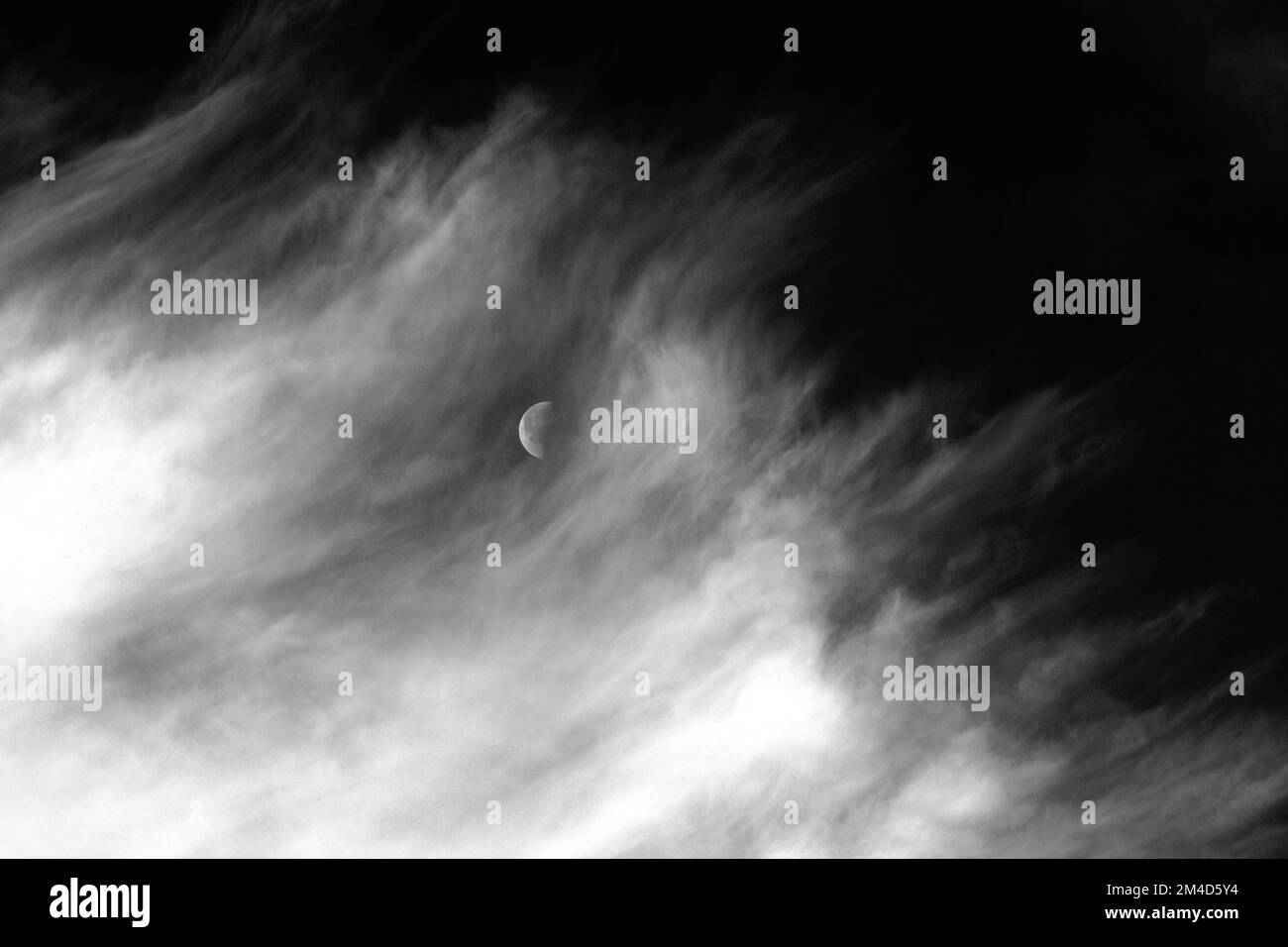 A half moon shares the sky with cirrus clouds over Santa Fe, New Mexico ...
