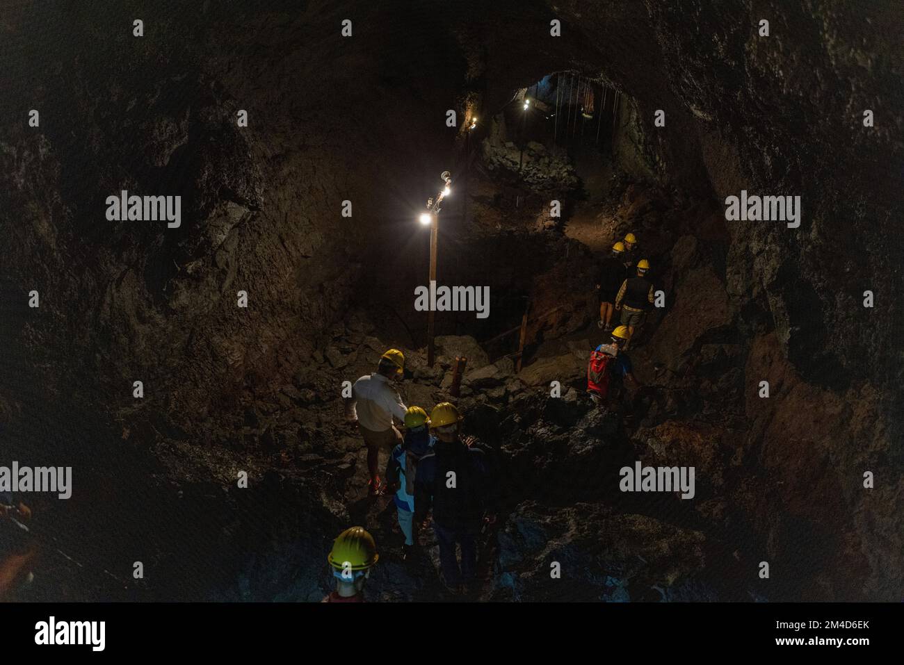 Group exploring a volcanic cave in the Volcanic Caves Park at the foot ...