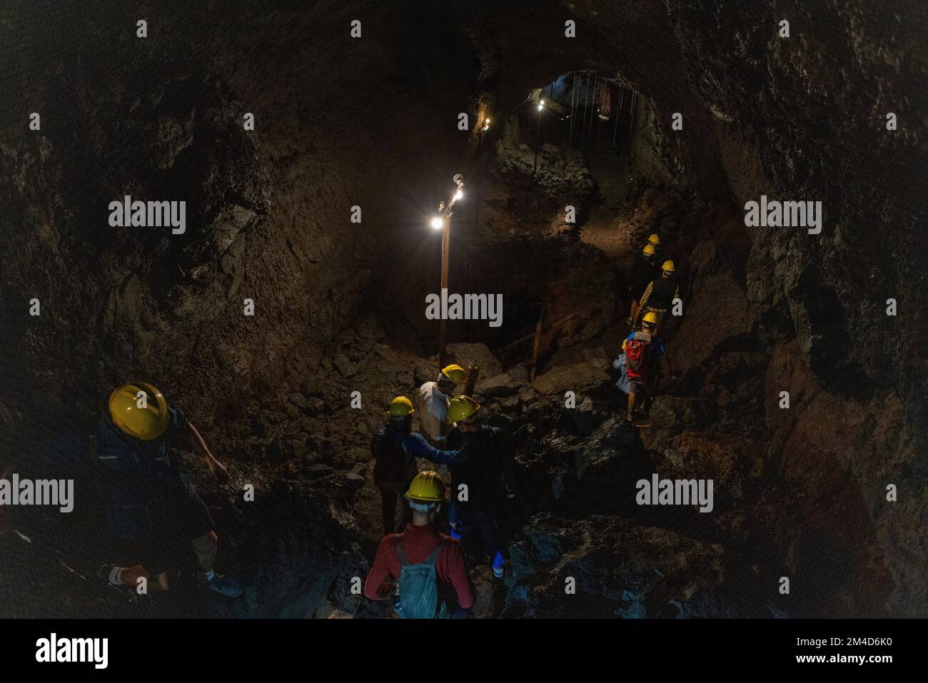 Group exploring a volcanic cave in the Volcanic Caves Park at the foot ...