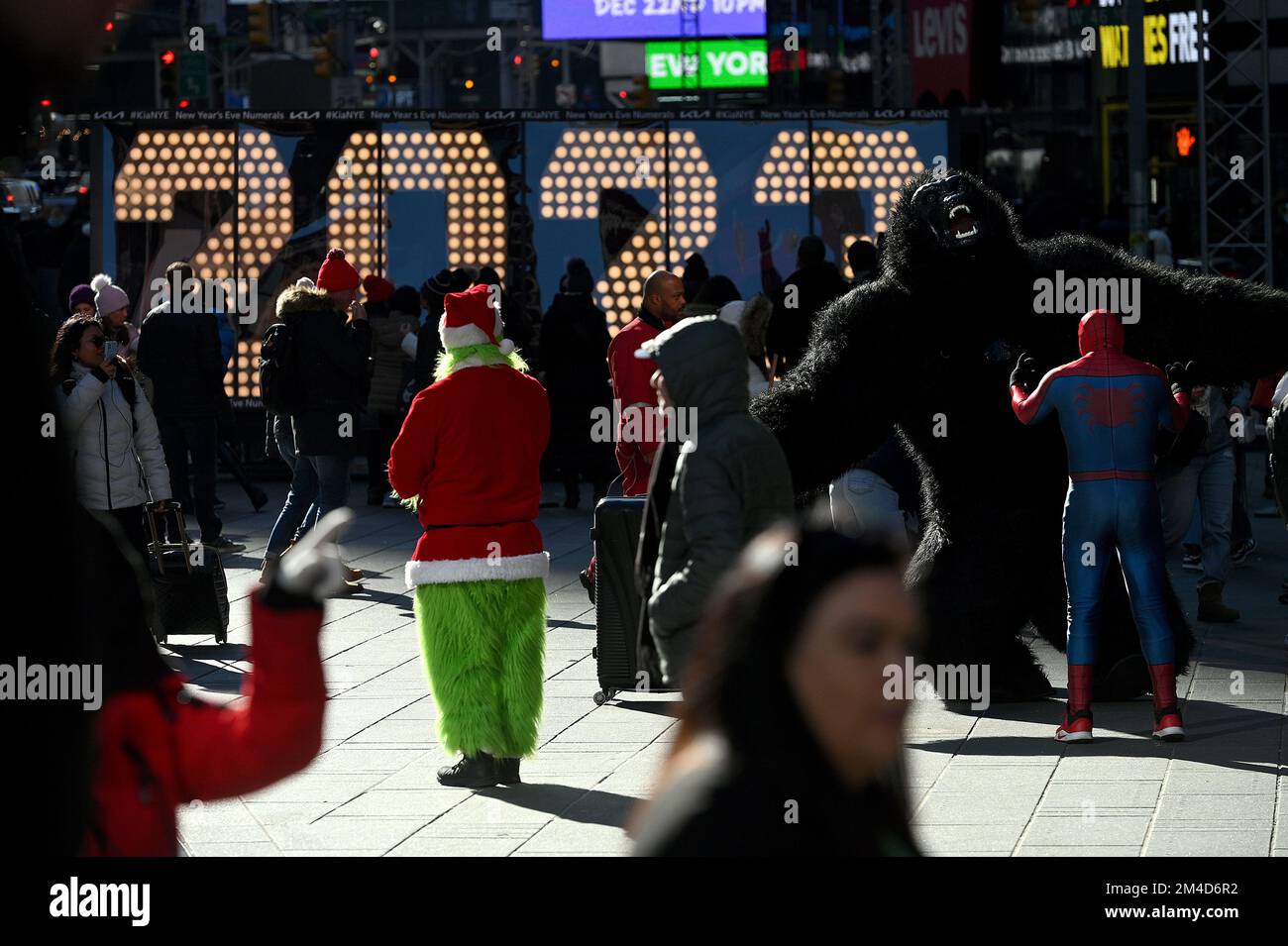 A busker in different costumes, include the Grinch and a person in an ...
