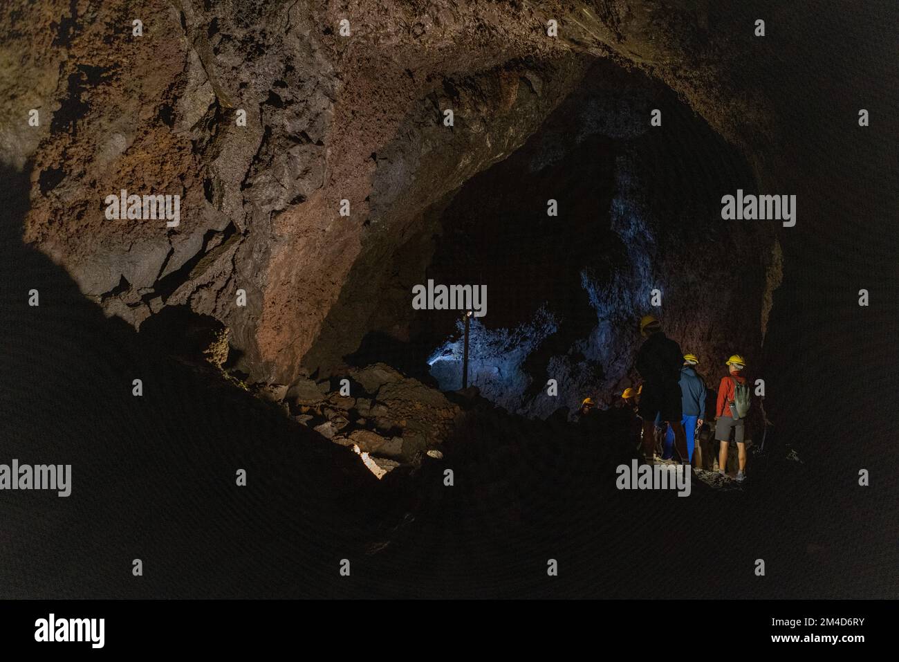 Group exploring a volcanic cave in the Volcanic Caves Park at the foot ...