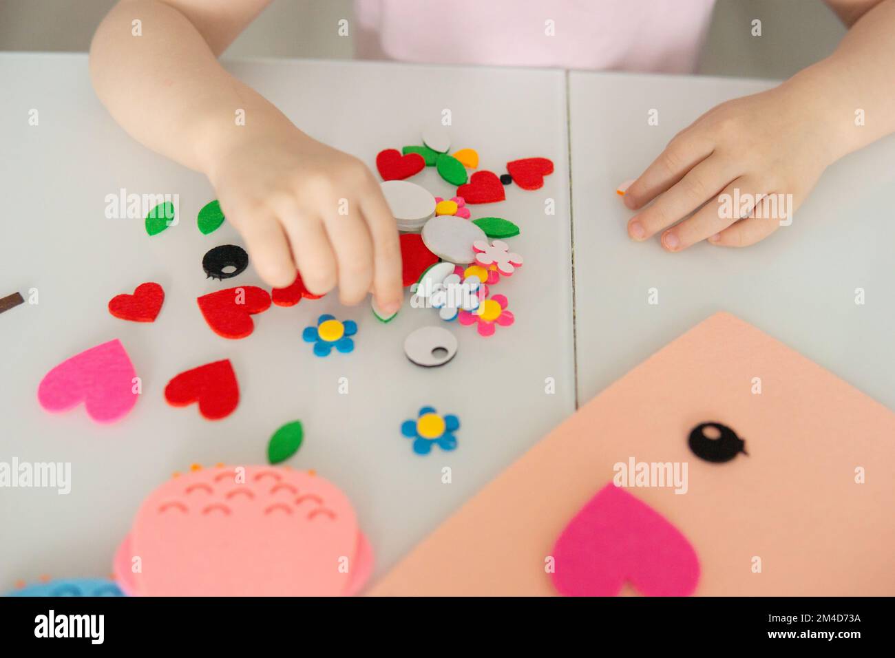 A blogger girl makes a felt craft for Valentine's Day in the shape of a ...