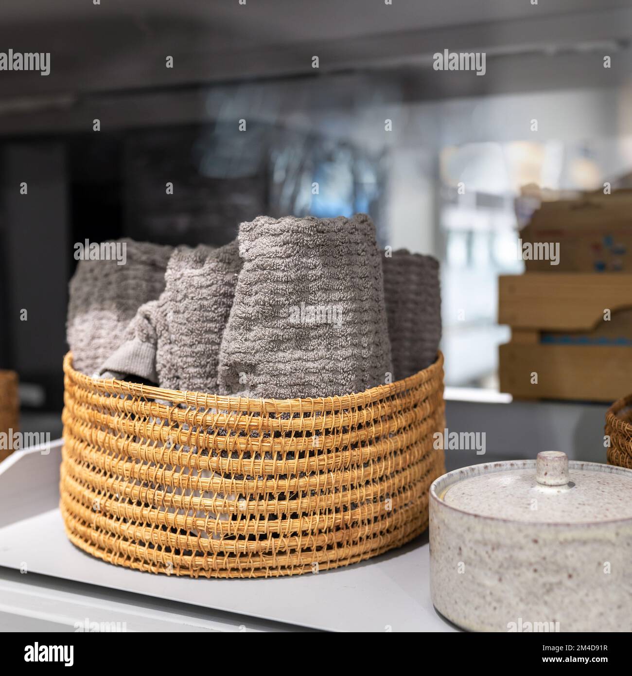 Rattan wicker basket with gray terry face towels in the bathroom Stock ...