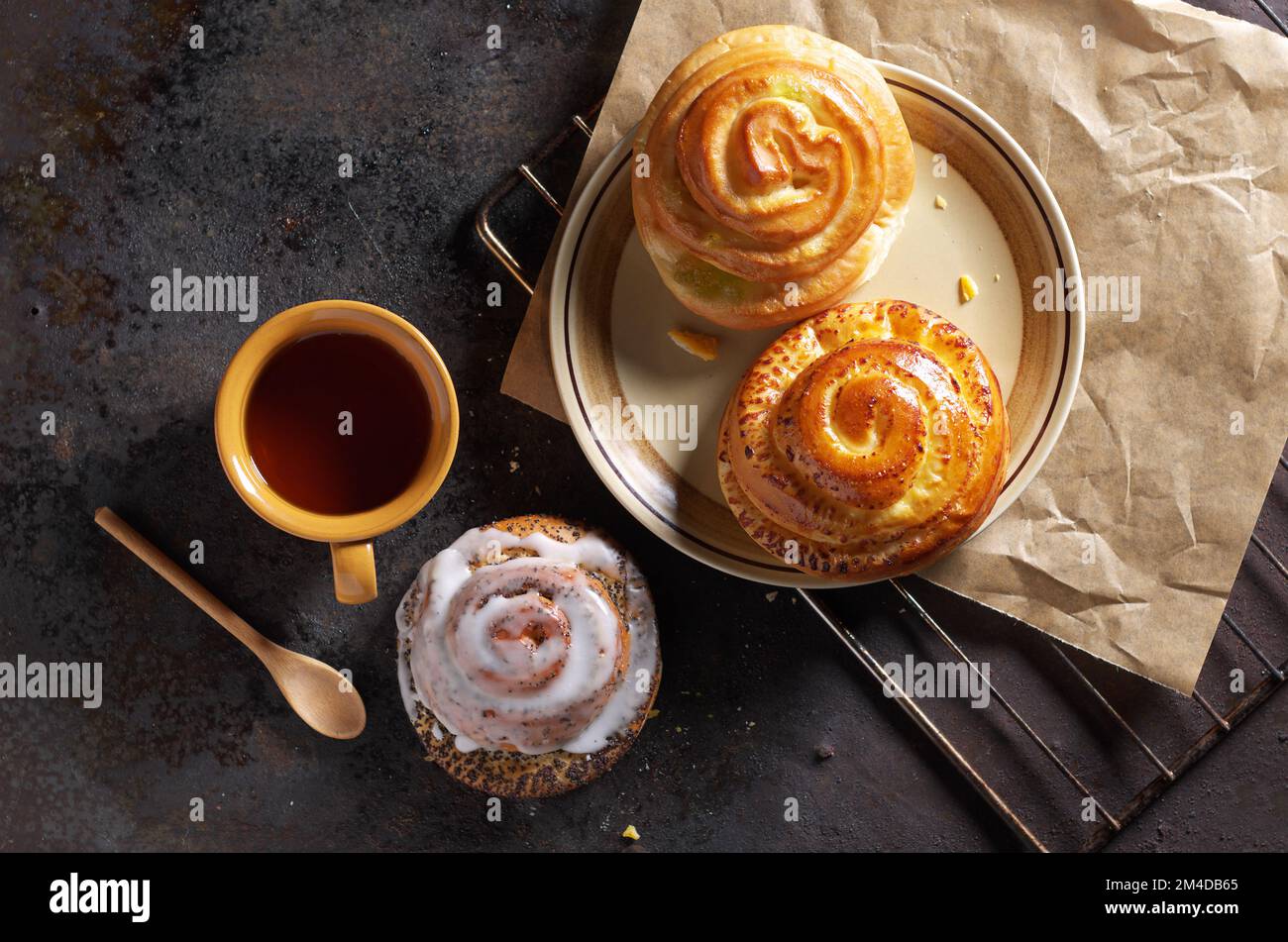 Different fresh buns and cup of tea on grunge background, top view ...