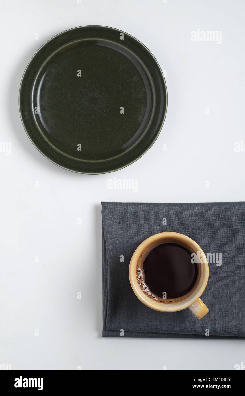 Cup of coffee and empty plate on white table, top view Stock Photo - Alamy