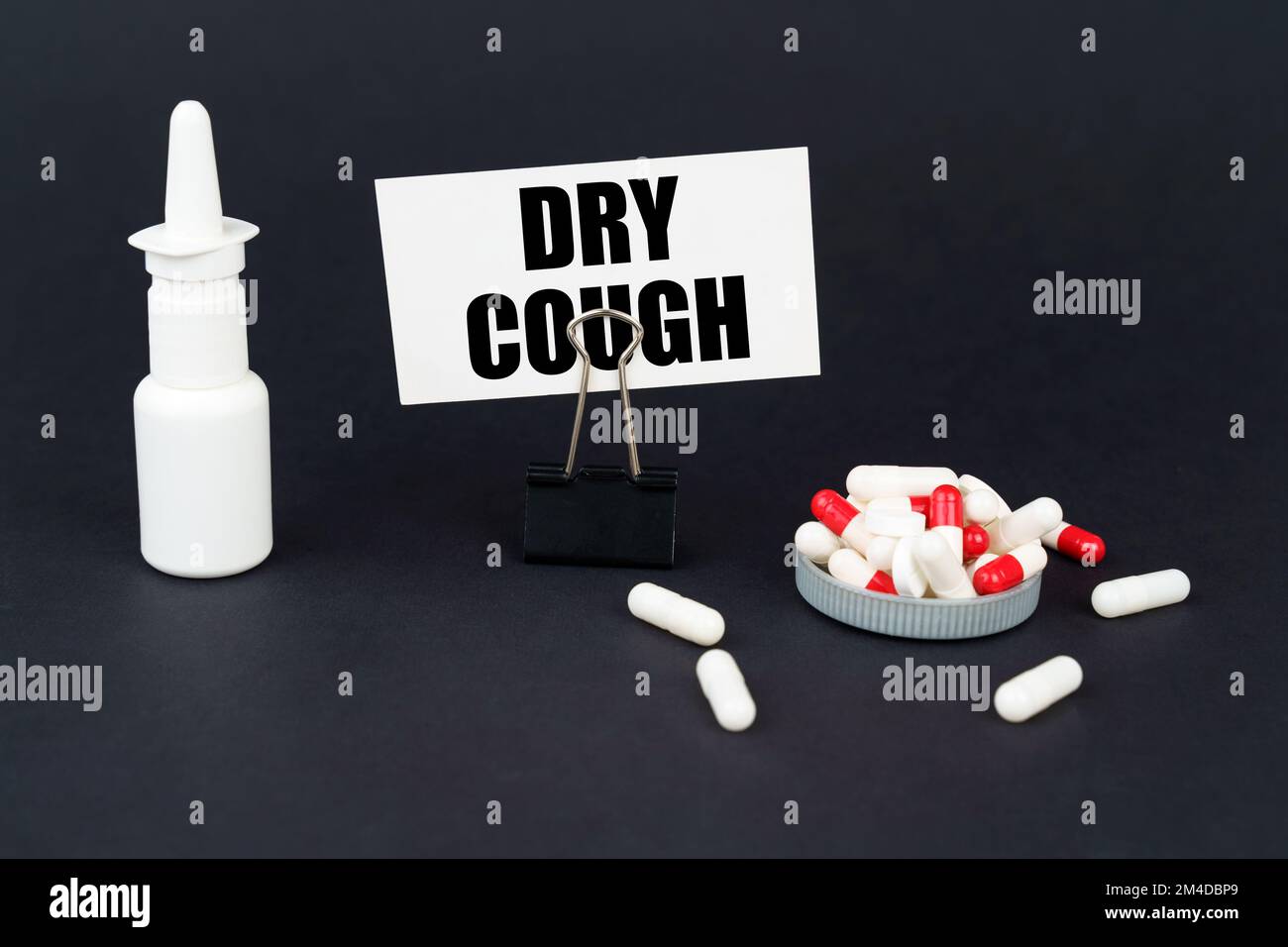 Medical concept. On the black surface of a pill, a nasal spray and a ...
