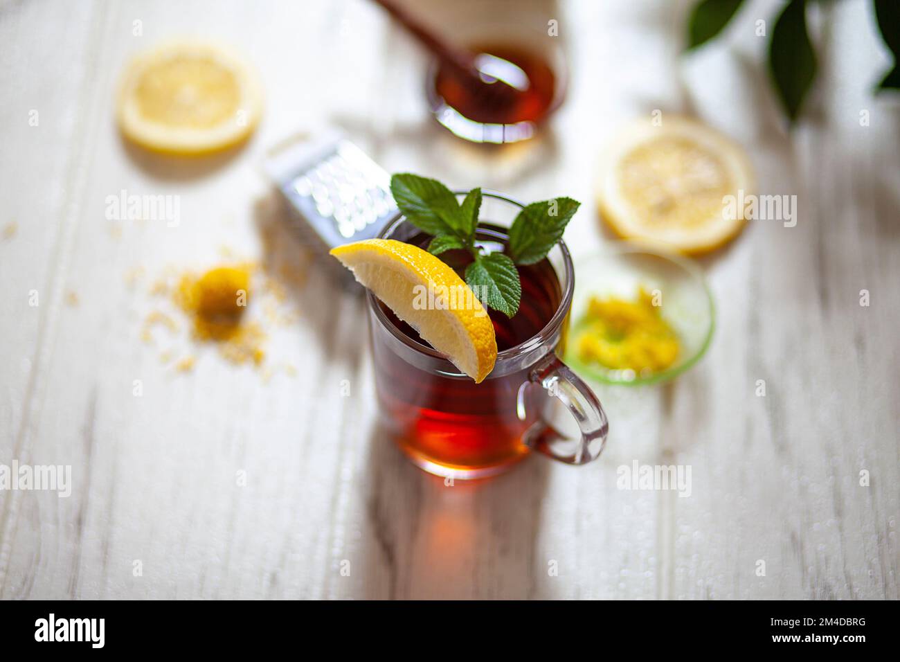 A horizontal shot of tea in a glass with lemon slices, mulberry leaves ...