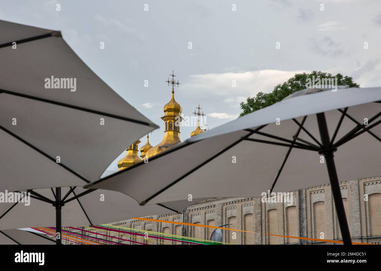 the gilded domes of the ancient church peek out from behind street ...