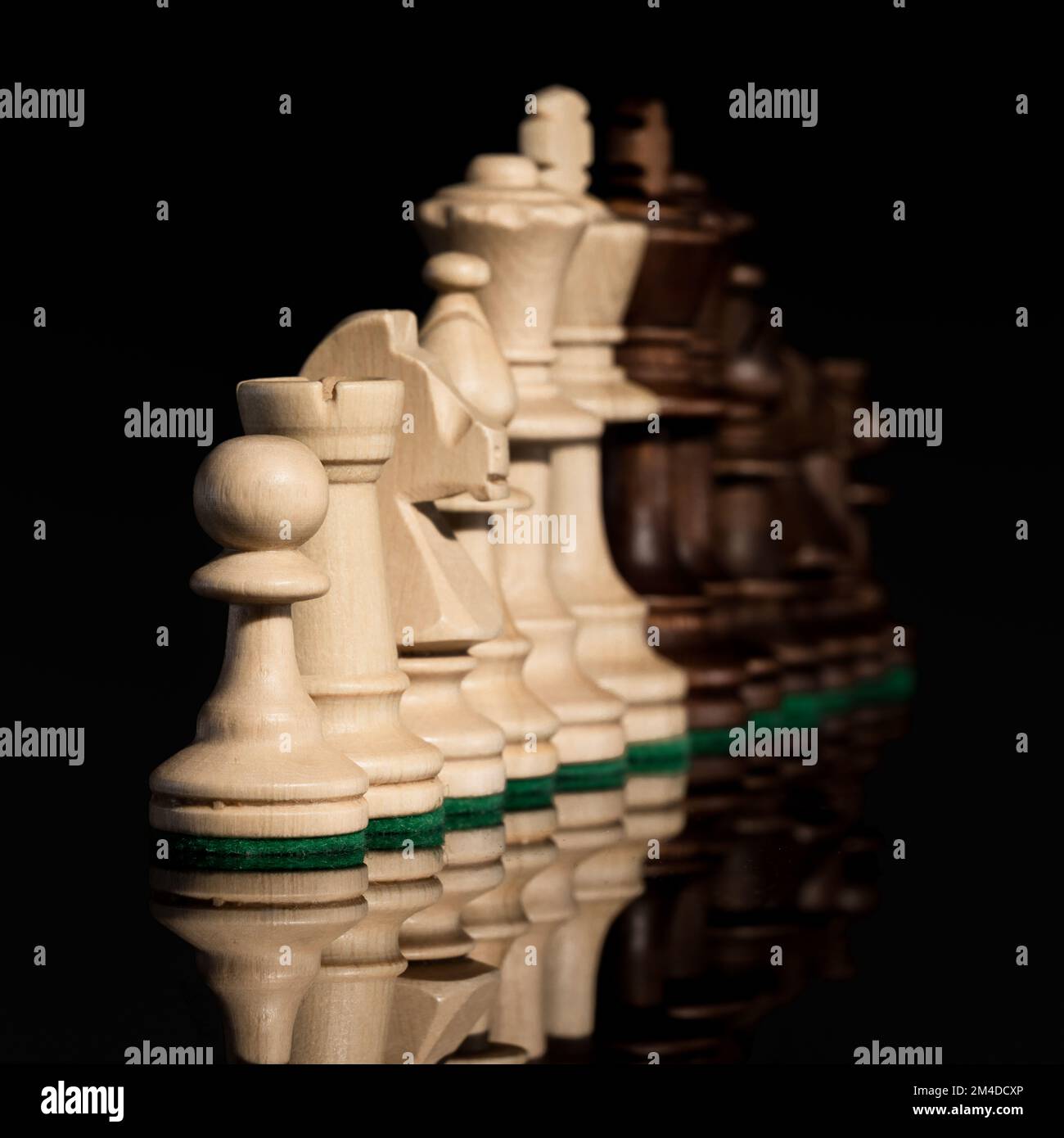Diagonal line of wooden chess pieces with selective focus isolated at ...