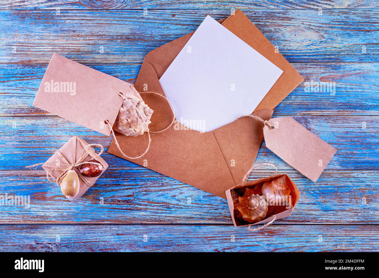 Top view of an envelope with a letter and seashells in gift bags with ...