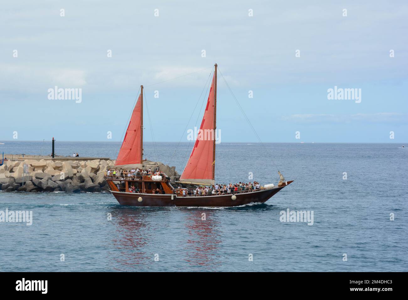 An oriental teak sailing boat with many tourists on board at sea ...