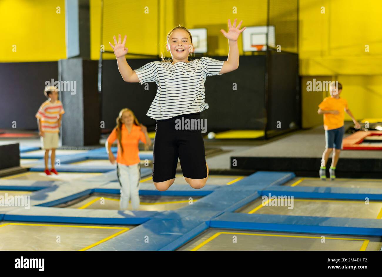 Tween girl having fun jumping in indoor trampoline arena Stock Photo ...