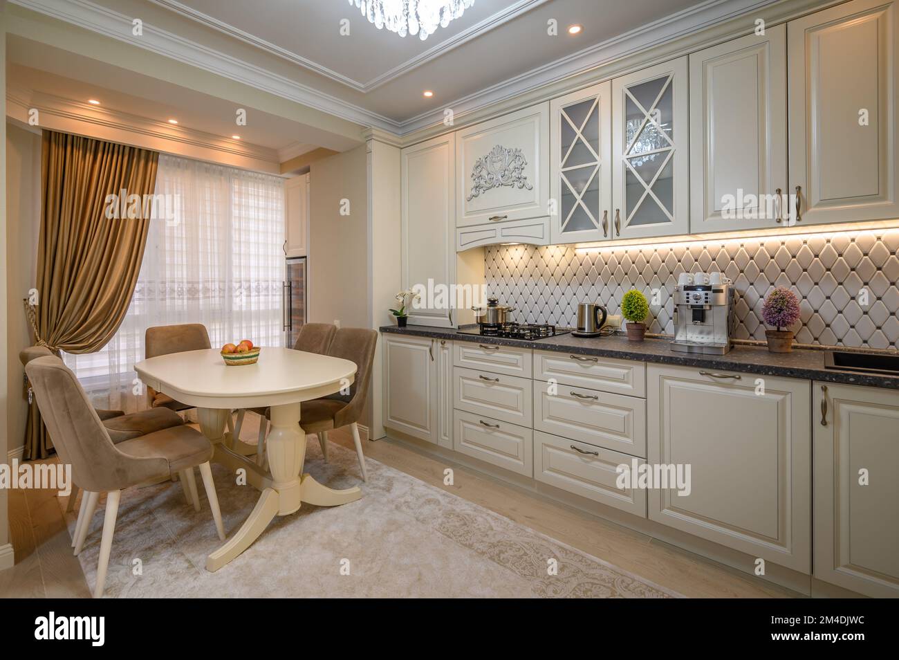 Spacious beige kitchen with a dining table and modern appliances Stock ...