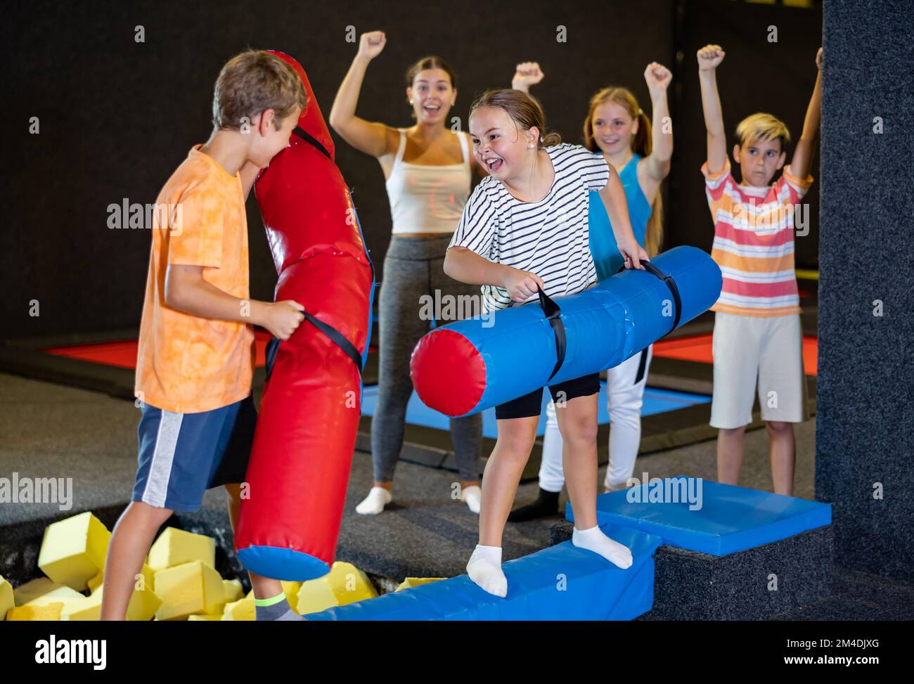 Cheerful school-age boy and girl friends having fun on inflatable ...