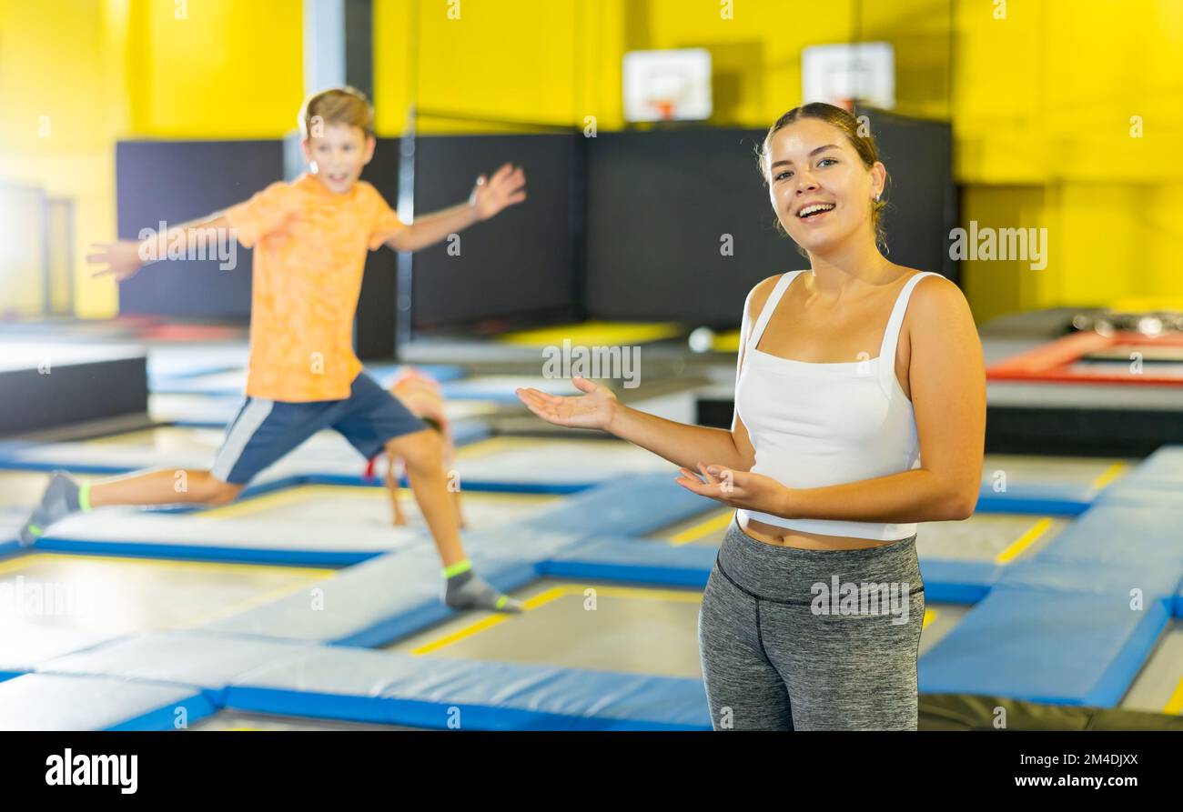 Teacher with children in trampoline center against background of ...