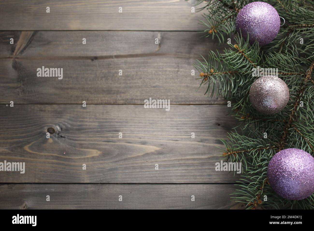 Christmas tree branch background with festive balls of purple silver ...