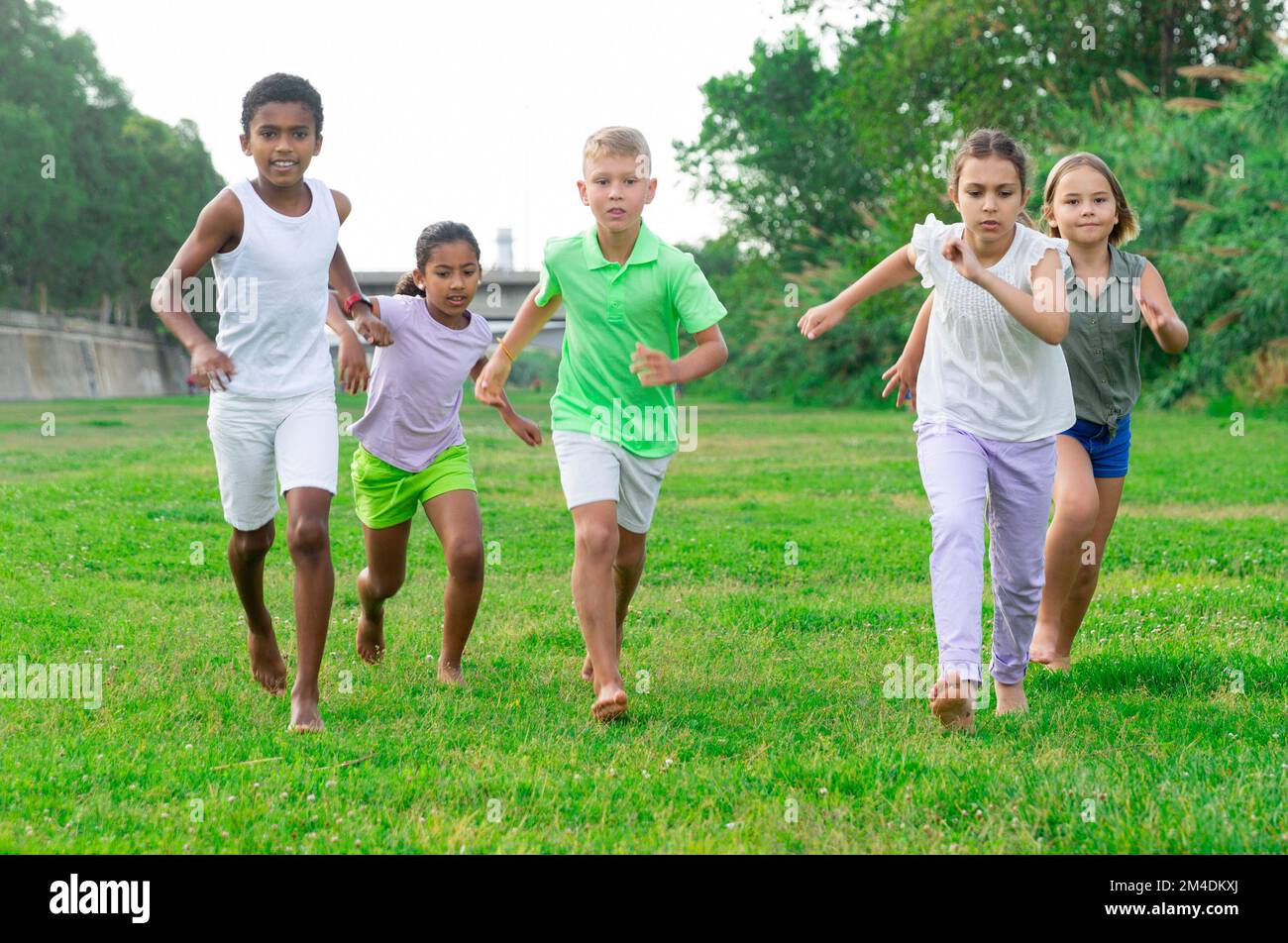 Five smiling kids running and laughing in park Stock Photo - Alamy