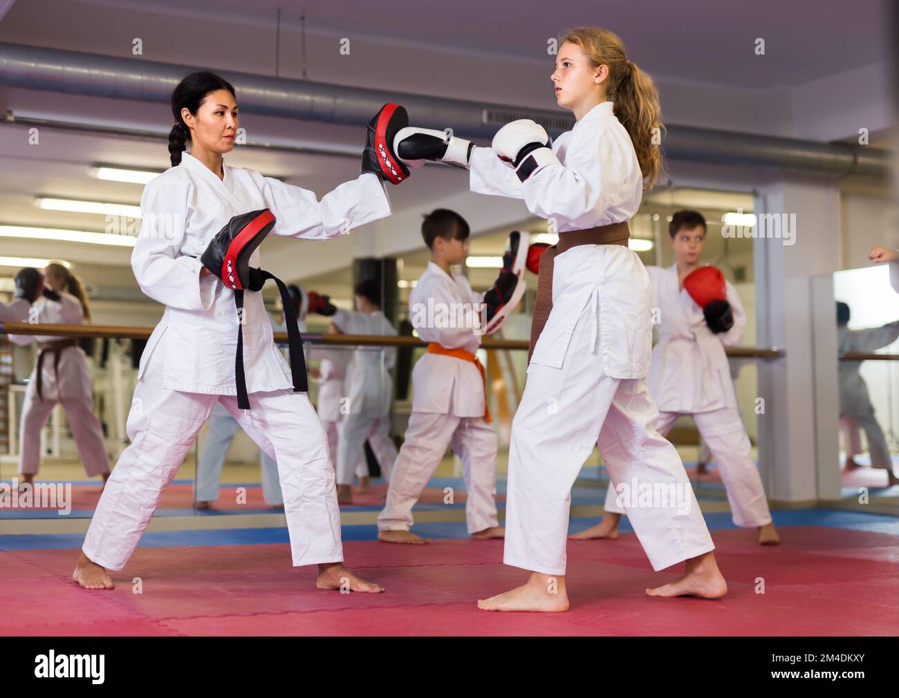 Girl launching blows on focus punch mitts Stock Photo - Alamy