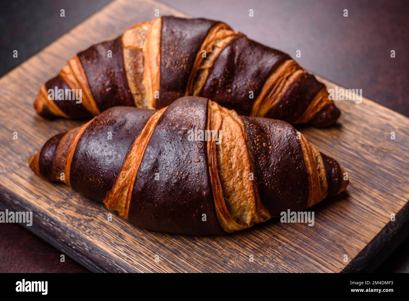 Beautiful tasty fresh crispy croissant on a dark concrete background ...